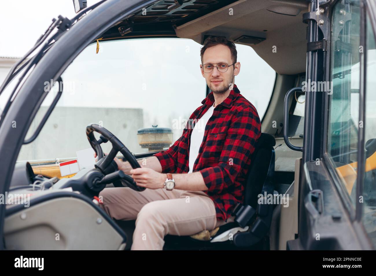 Young Rural Tractor or Combine driver sitting in the cab. Farming and ...