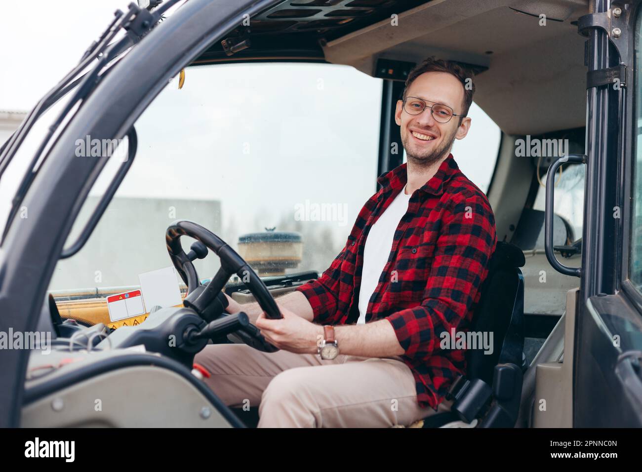 Young Rural Tractor or Combine driver sitting in the cab. Farming and ...