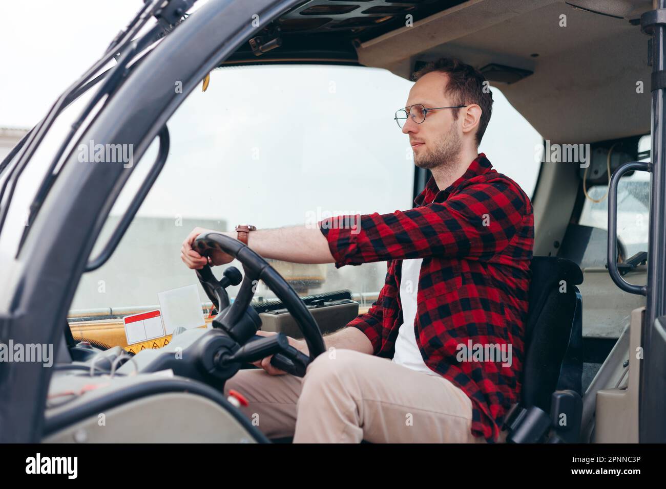 Young Rural Tractor or Combine driver sitting in the cab. Farming and ...