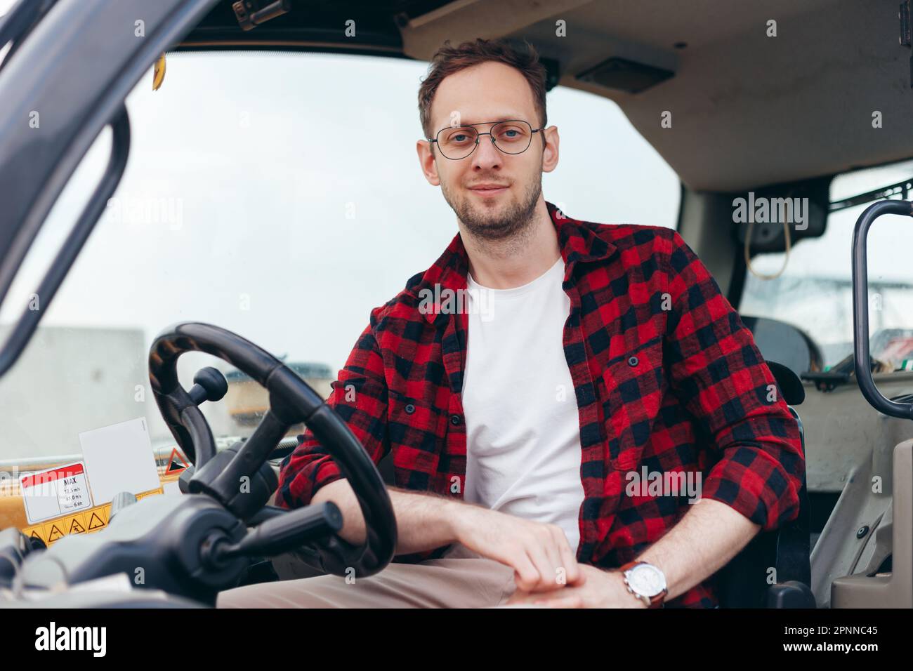 Young Rural Tractor or Combine driver sitting in the cab. Farming and ...