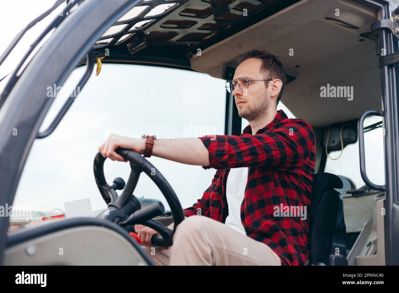 Young Rural Tractor or Combine driver sitting in the cab. Farming and ...