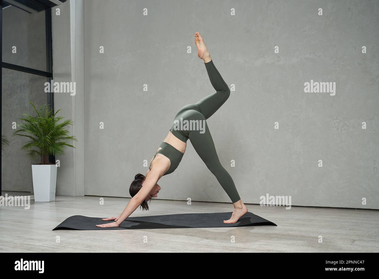 Flexible, active lady exercising, working out, practising in studio ...