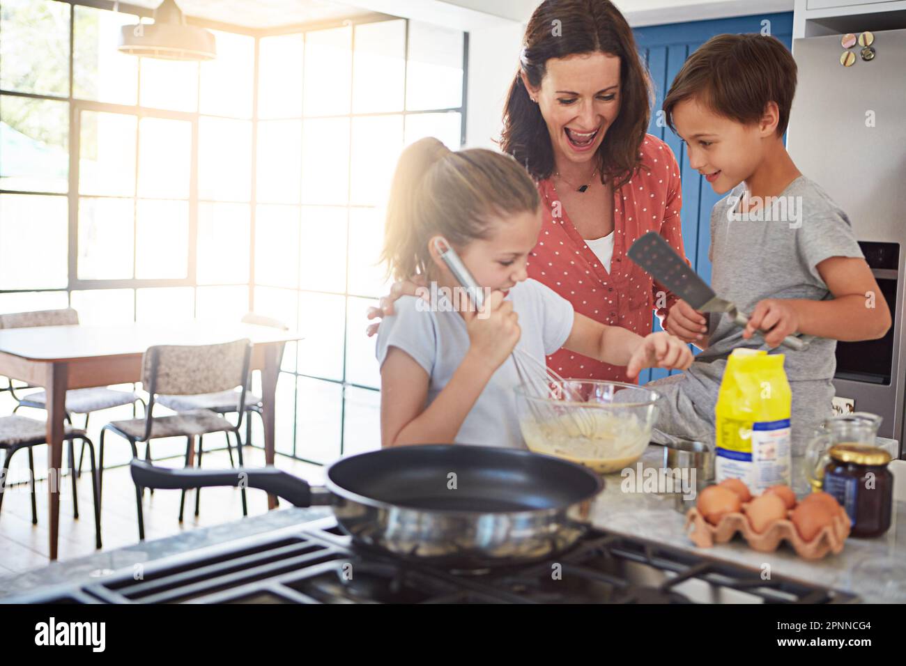 Her kids love baking. a mother baking with her children in the kitchen ...