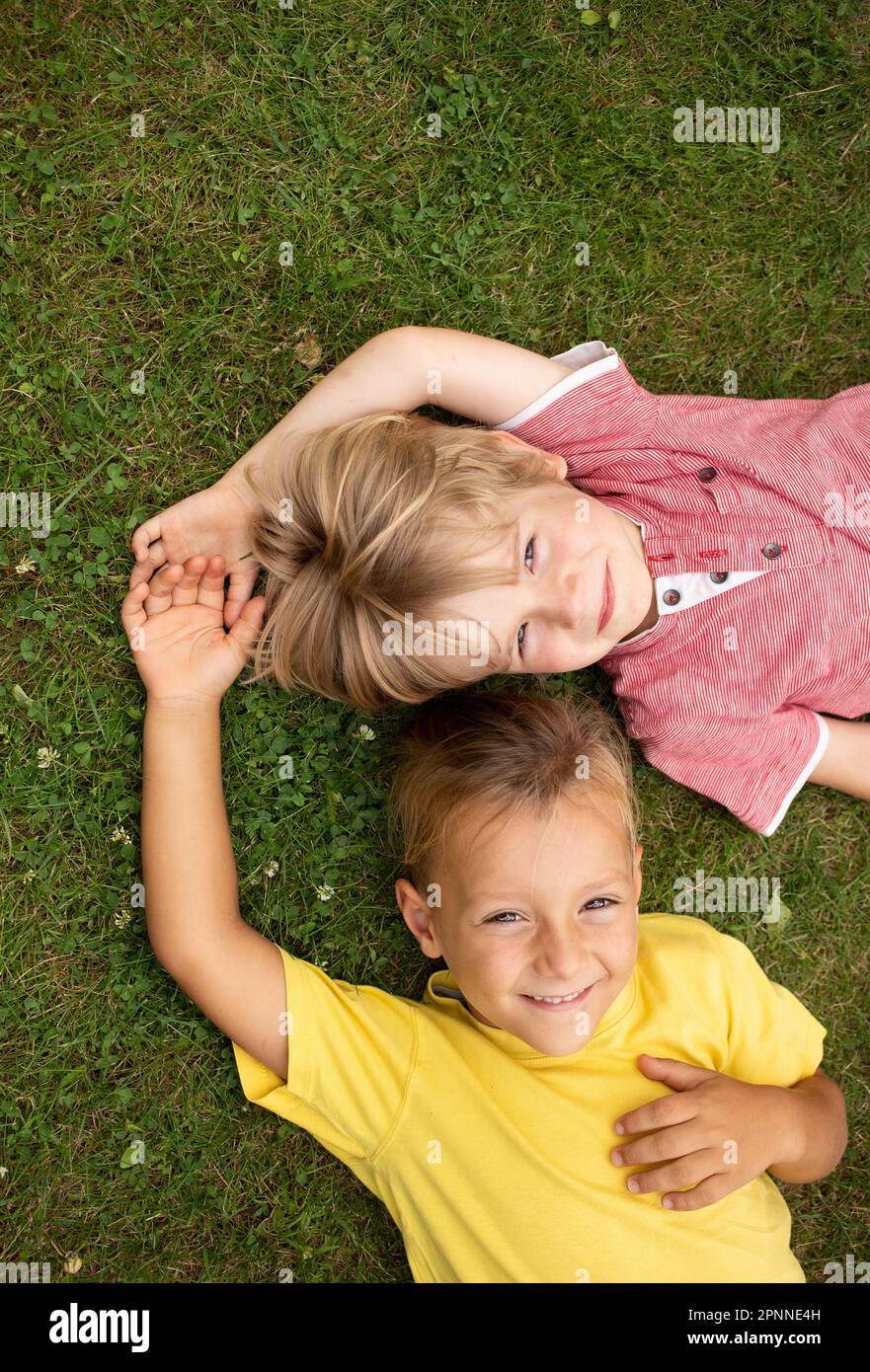 two boys of preschool age - tired of active games, lie on their backs ...
