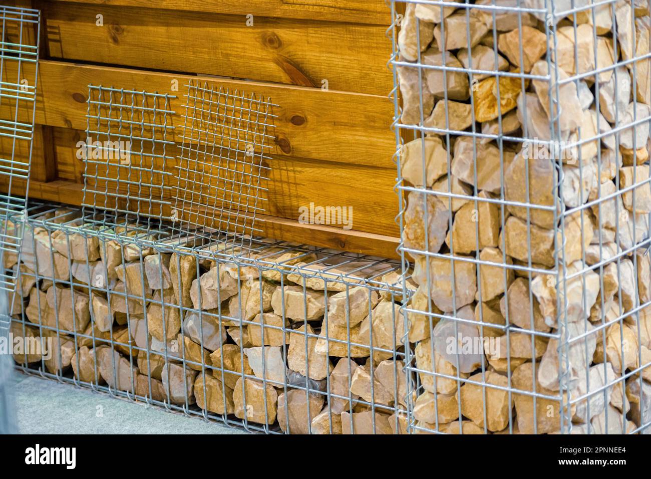Foundation and supports of a fence made of metal mesh and stones Stock ...