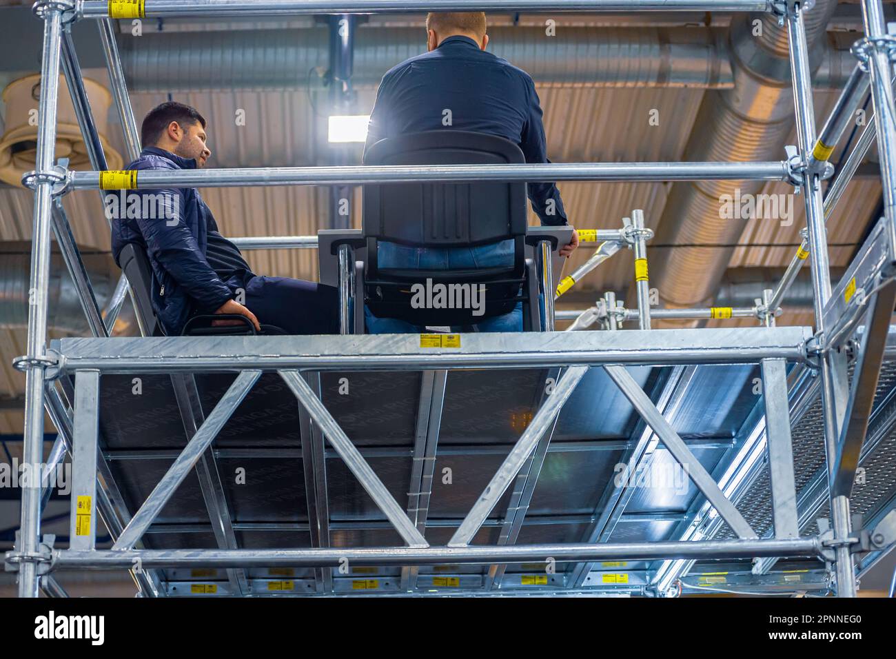 Kiev, Ukraine - March 20, 2021:Men businessmen sit on a scaffolding ...