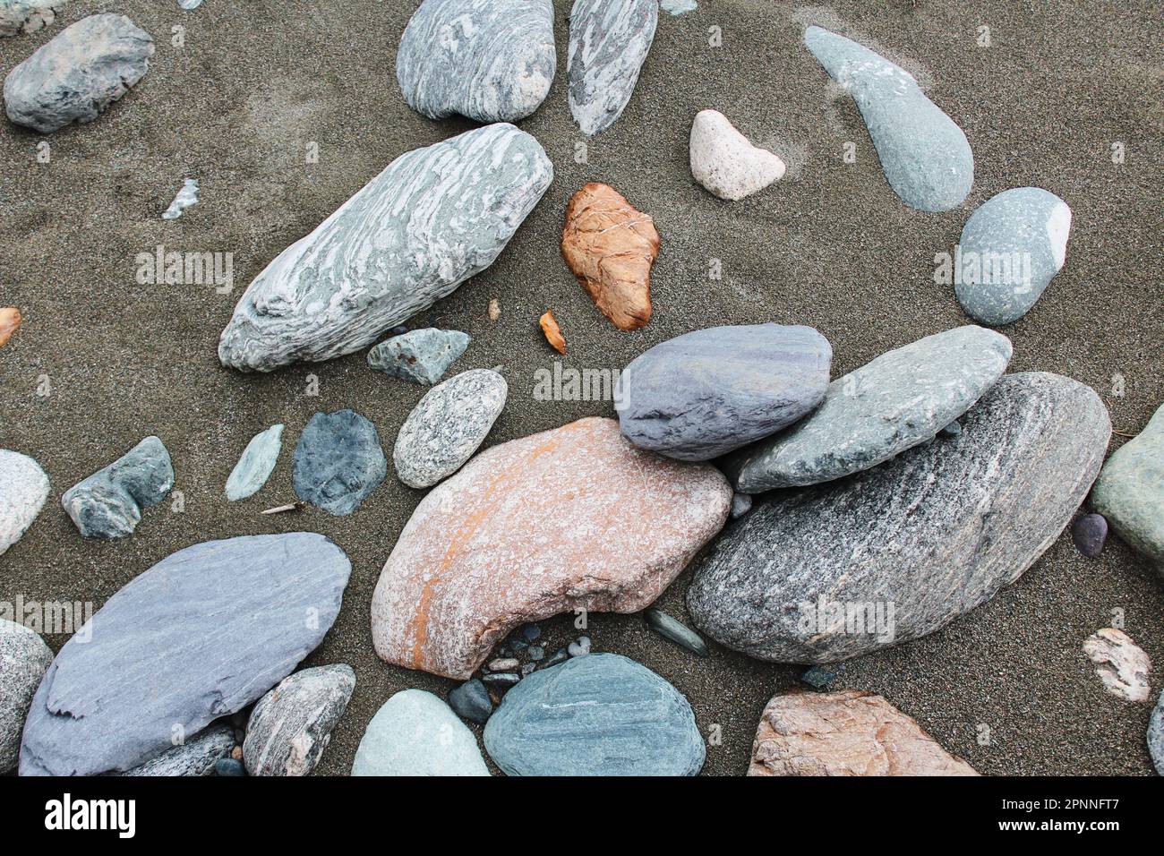Stones of different breeds and colors lie in the sand. regional ...