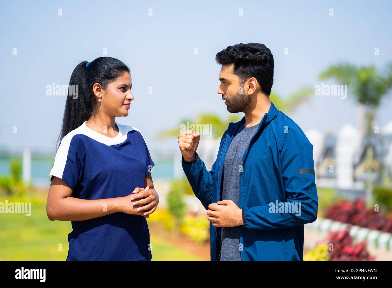 serious Young Indian people doing stretching exercise by touching feet ...