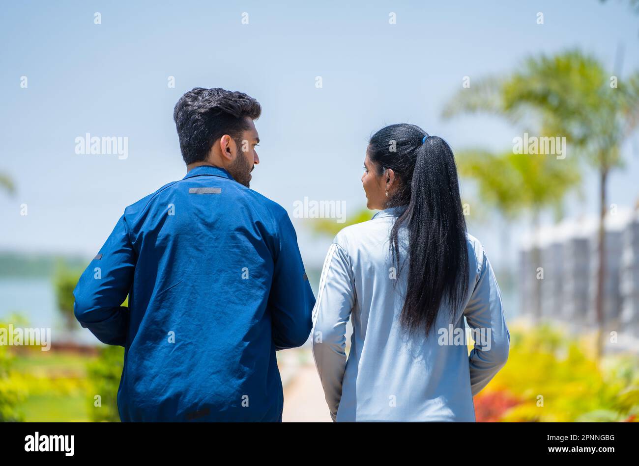 Rear view tracking of shot of couples running or jogging at park ...