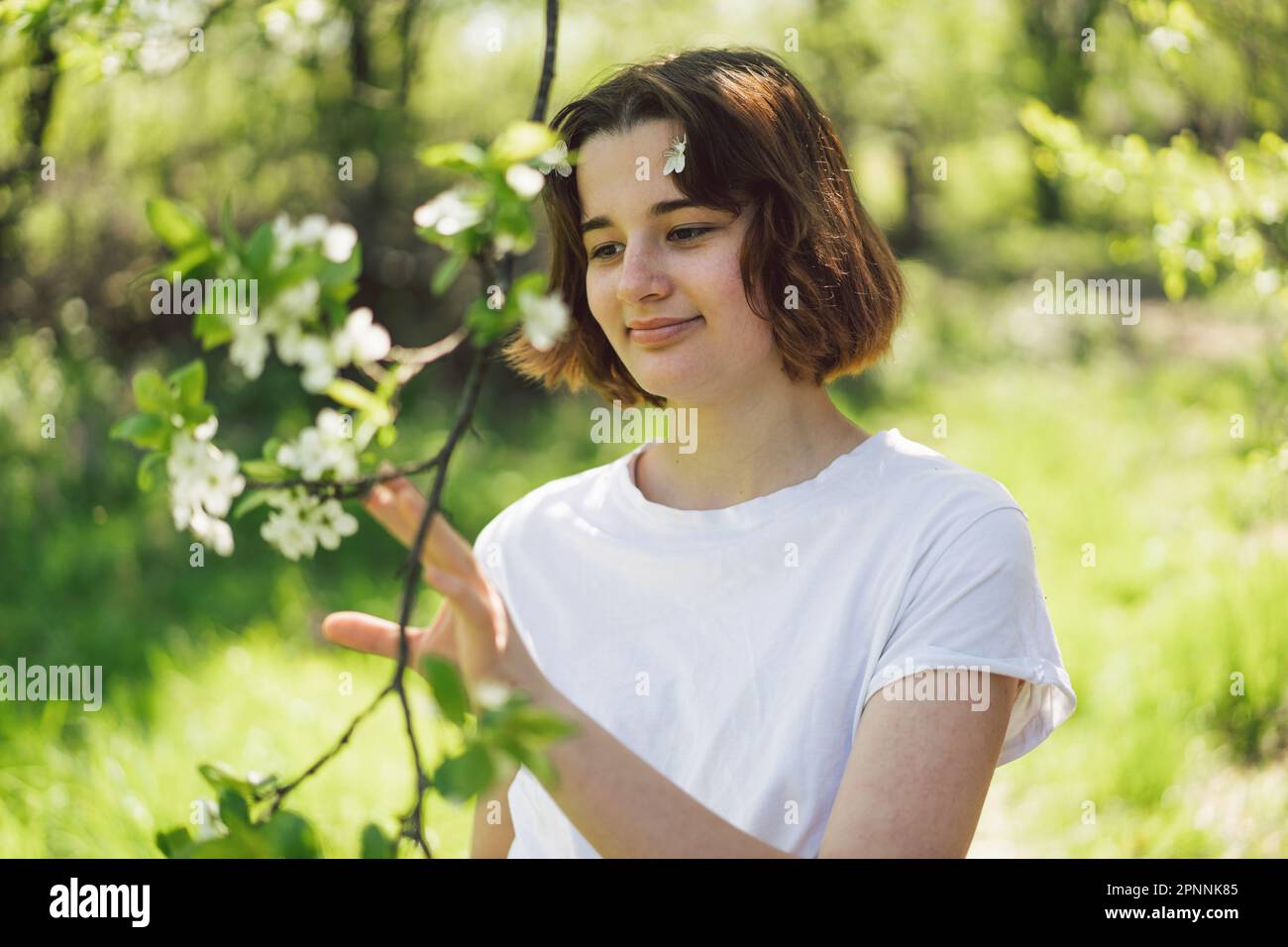Beautiful teenage girl with spring flowers enjoying nature and laughing ...