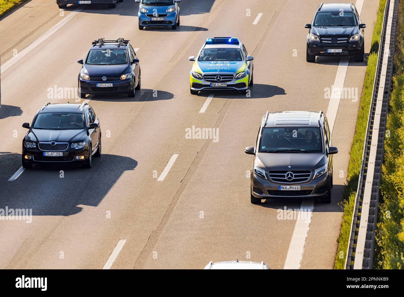 Traffic with congestion on the motorway, a police vehicle driving ...