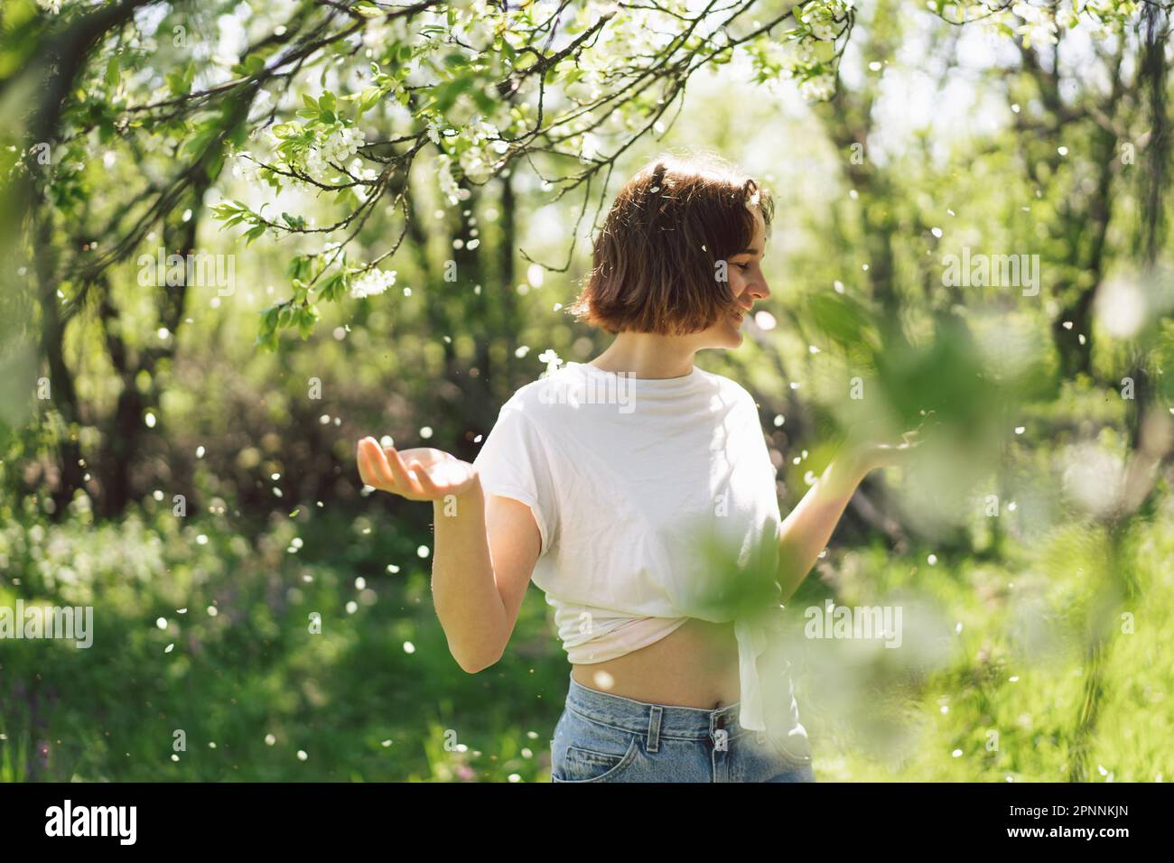 Beautiful teenage girl with spring flowers enjoying nature and laughing ...