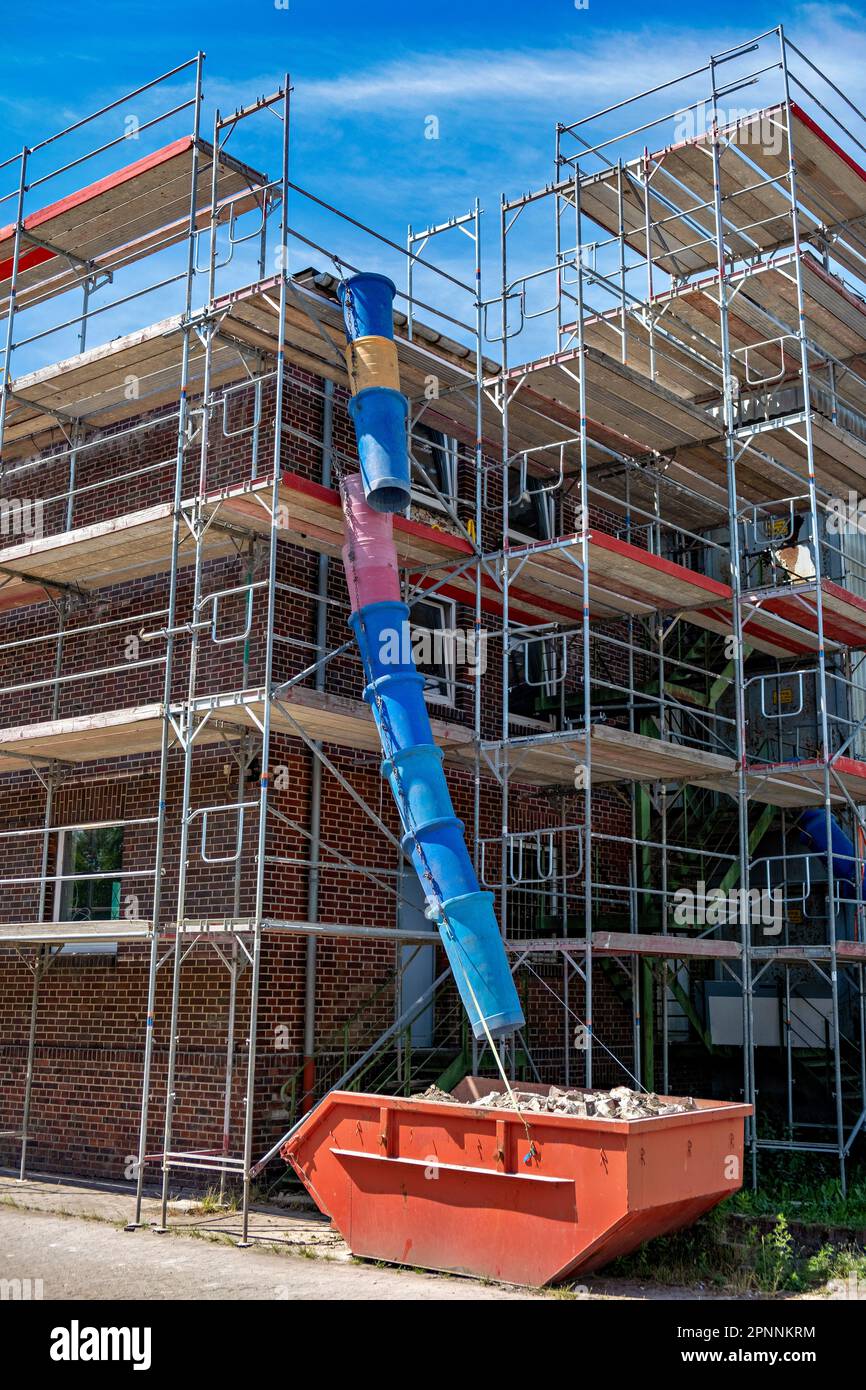 Suspended sections of blue construction garbage chute on a building ...