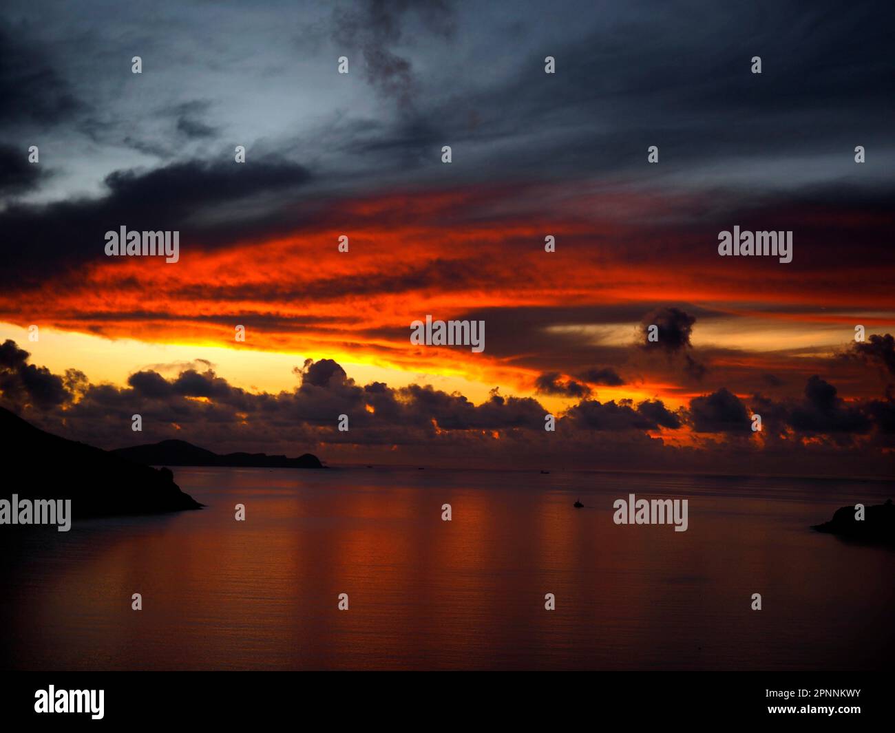 A breathtaking view of a fiery sunset reflecting off the glassy water ...