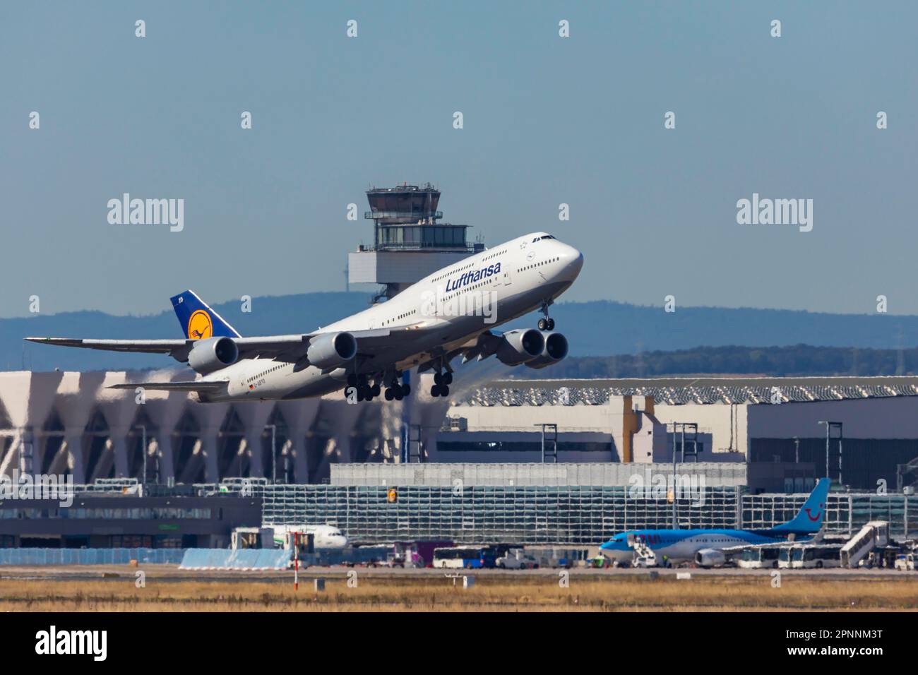 Boeing 747-400 of the airline Lufthansa during take-off at Fraport Airport, Tower and Terminal ...