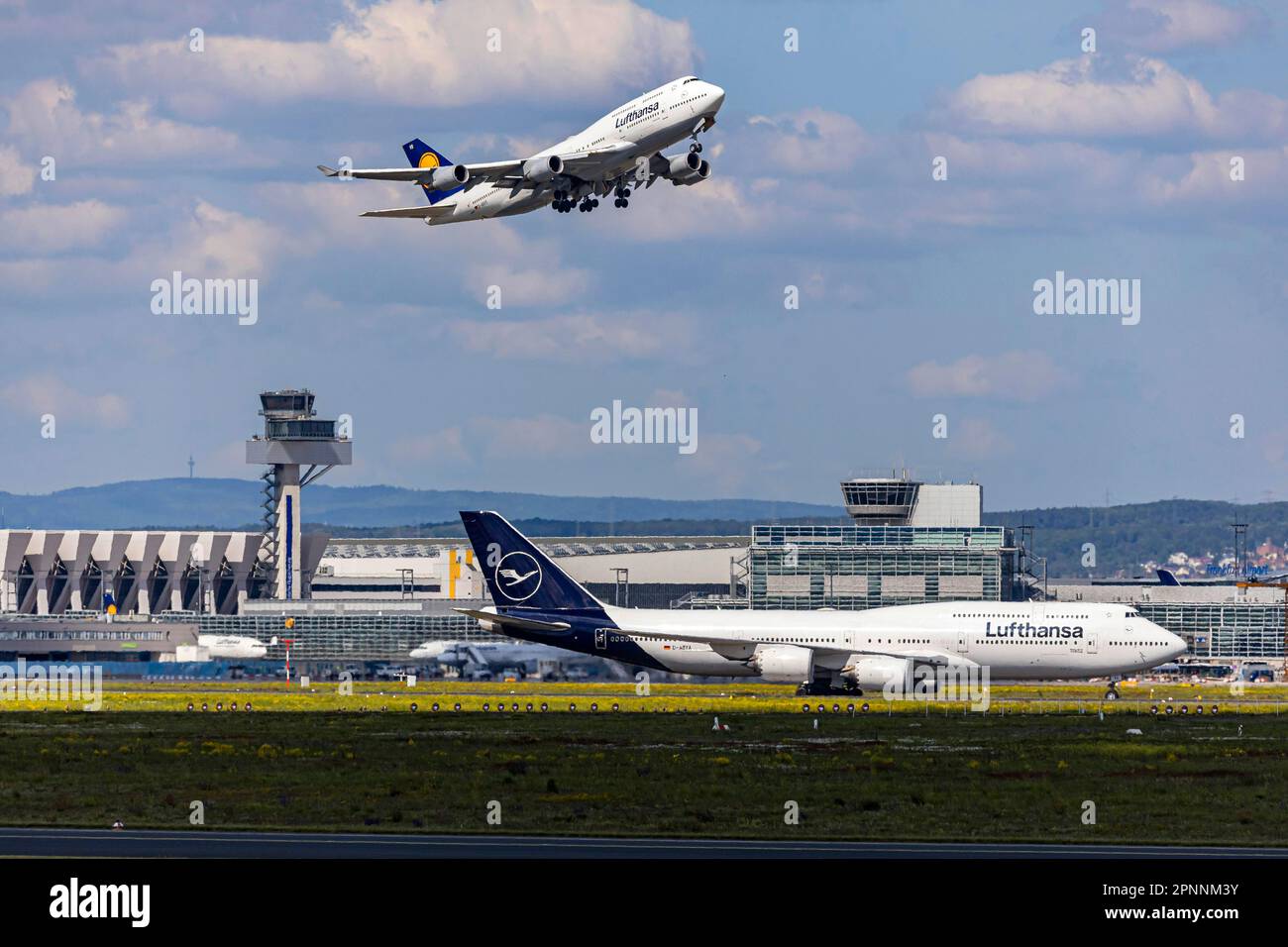 Boeing 747-400 of the airline Lufthansa during take-off at Fraport Airport, Tower and Terminal ...