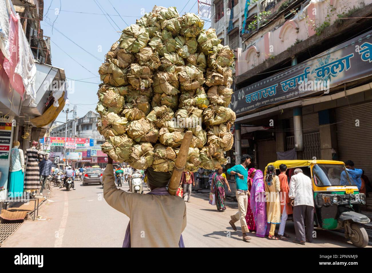 A man carries a heavy load on his head, transporting goods in the Hindu ...