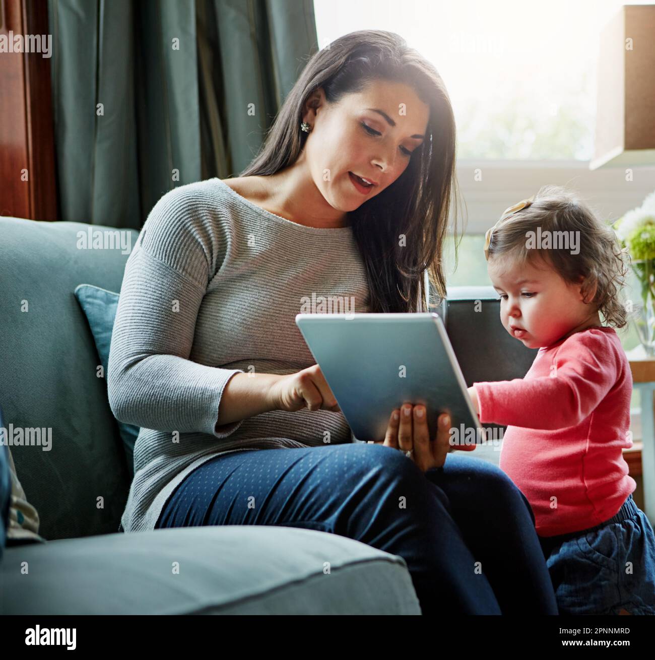 Assisting her childs learning through technology. a mother and her ...