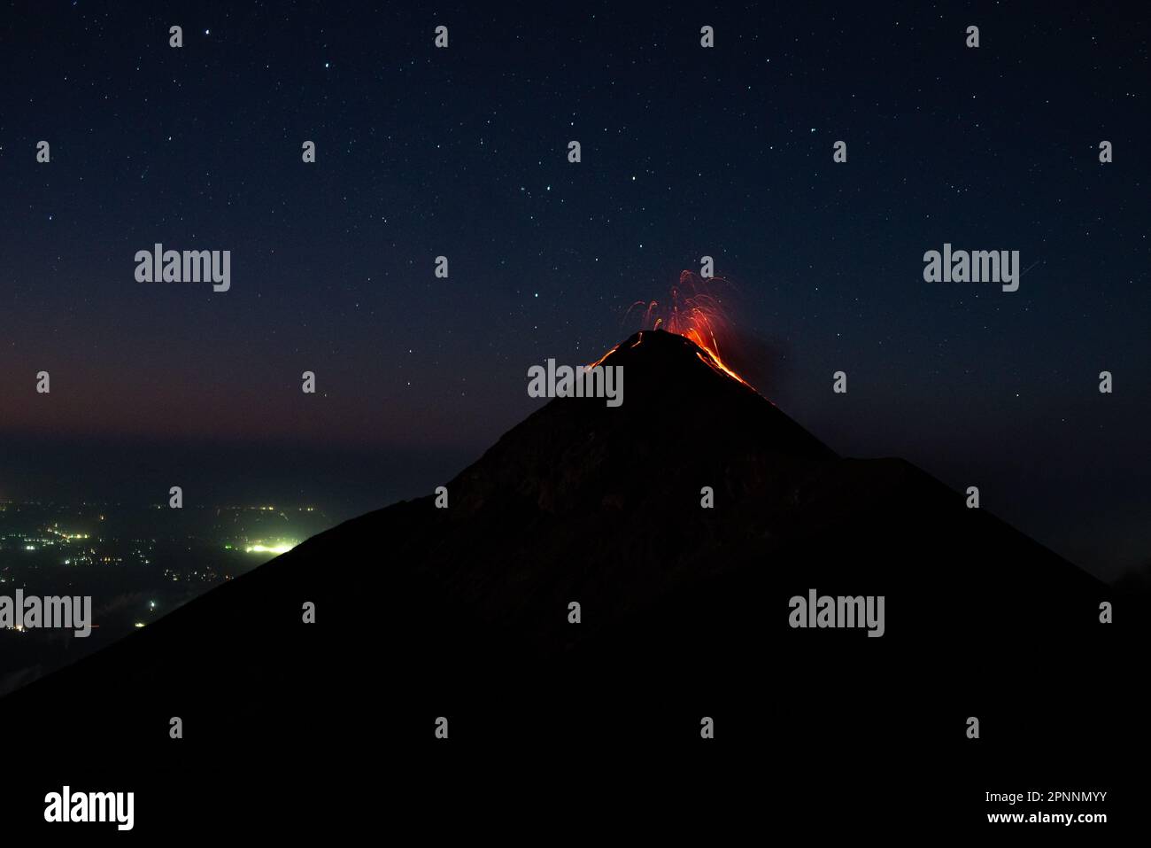 A dramatic shot of a volcanic eruption, with a cloud of ash and lava ...