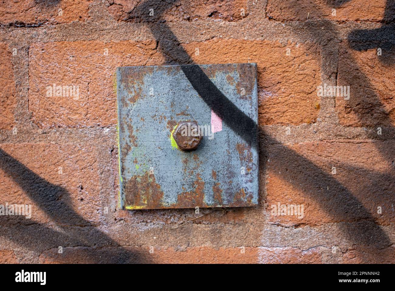 iron and steel retaining plate and bolt in a red brick wall with ...