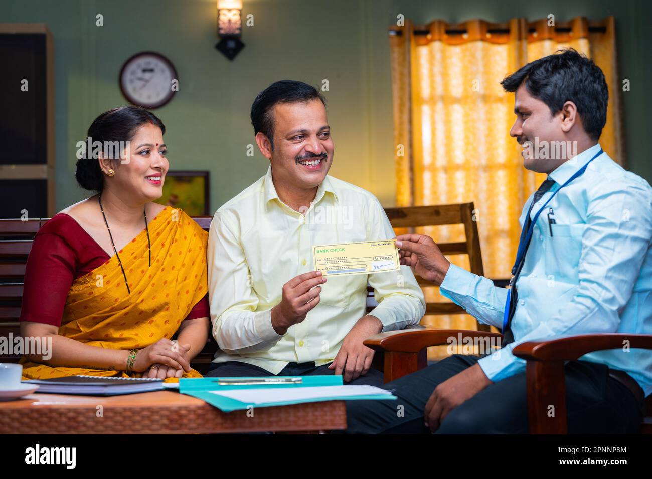Happy middle aged couple receiving cheque from banker at home - concept ...