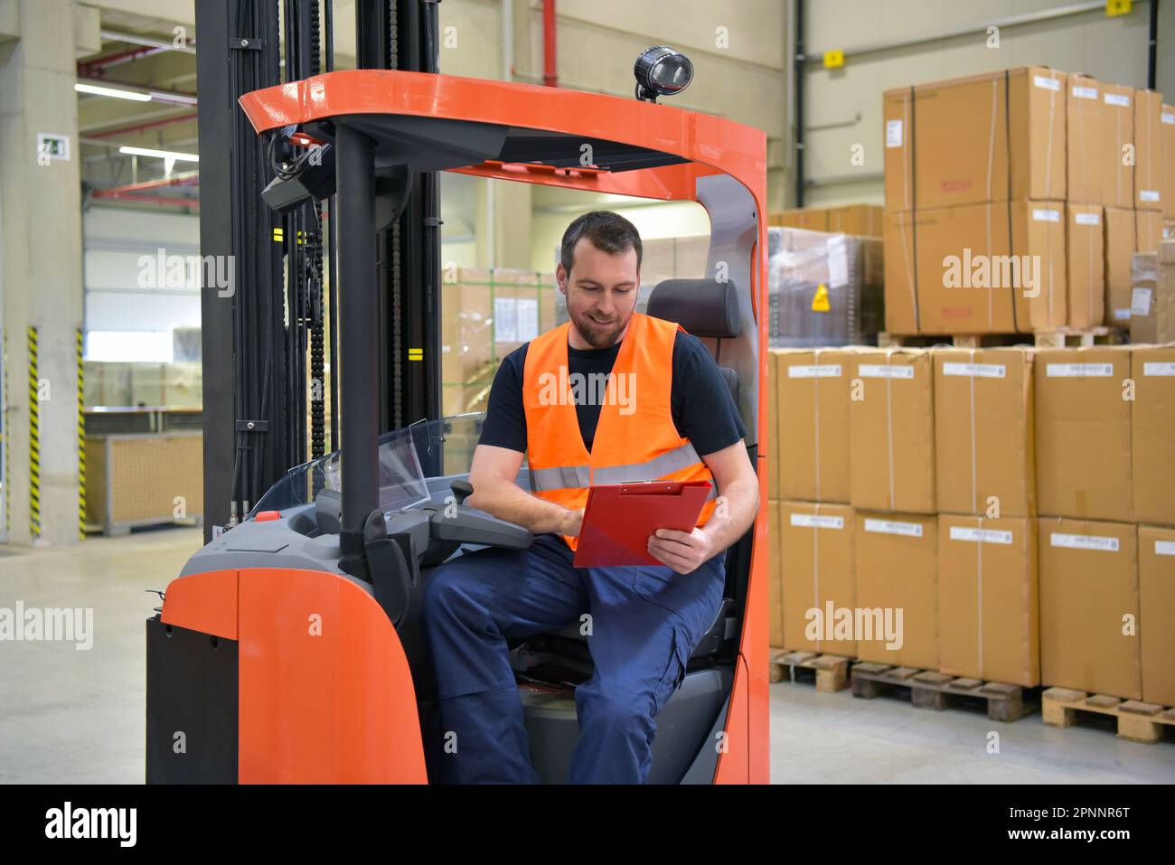 warehouse worker in a forwarding agency - interior with forklift ...