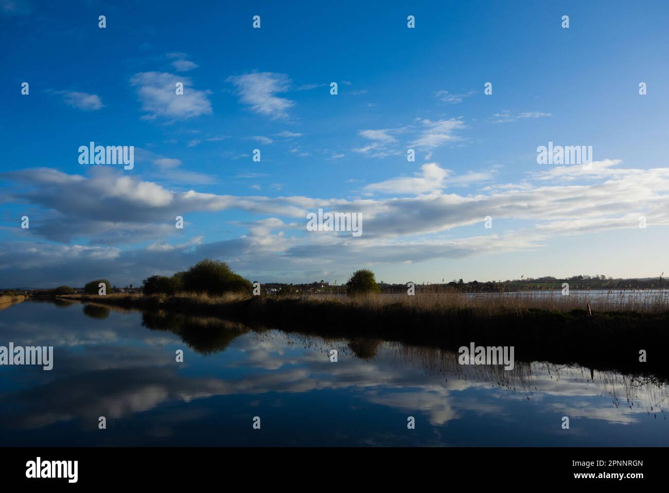 sunrise at the Exeter Ship Canal at Topsham with a few clouds reflected ...