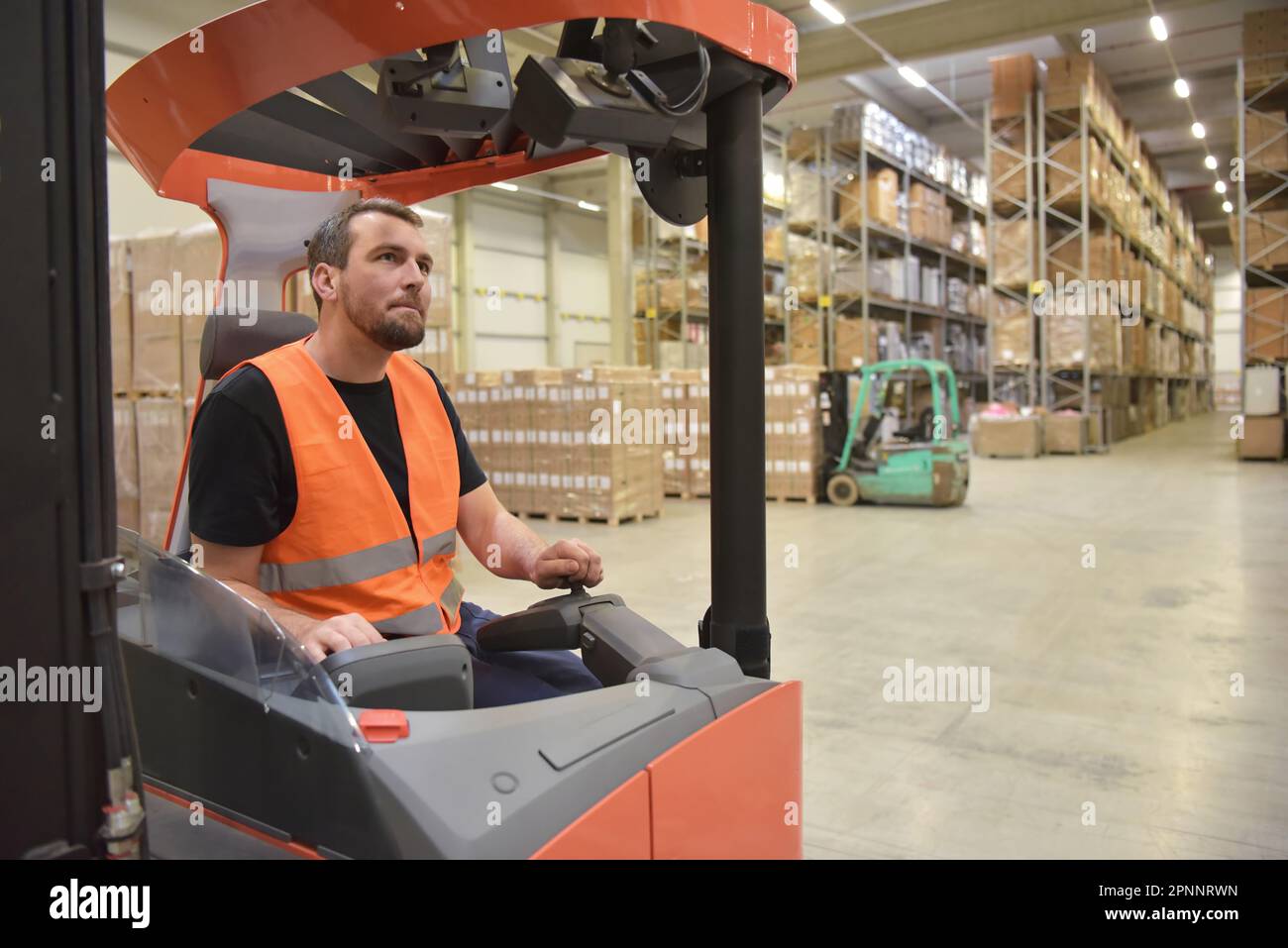 warehouse worker in a forwarding agency - interior with forklift ...