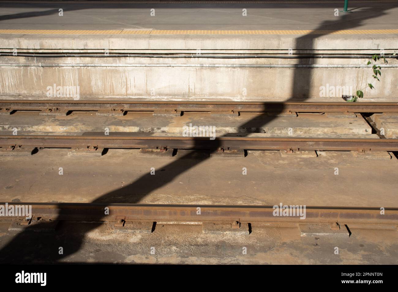 two sets of train lines in bright sunlight with line of shadow Stock ...