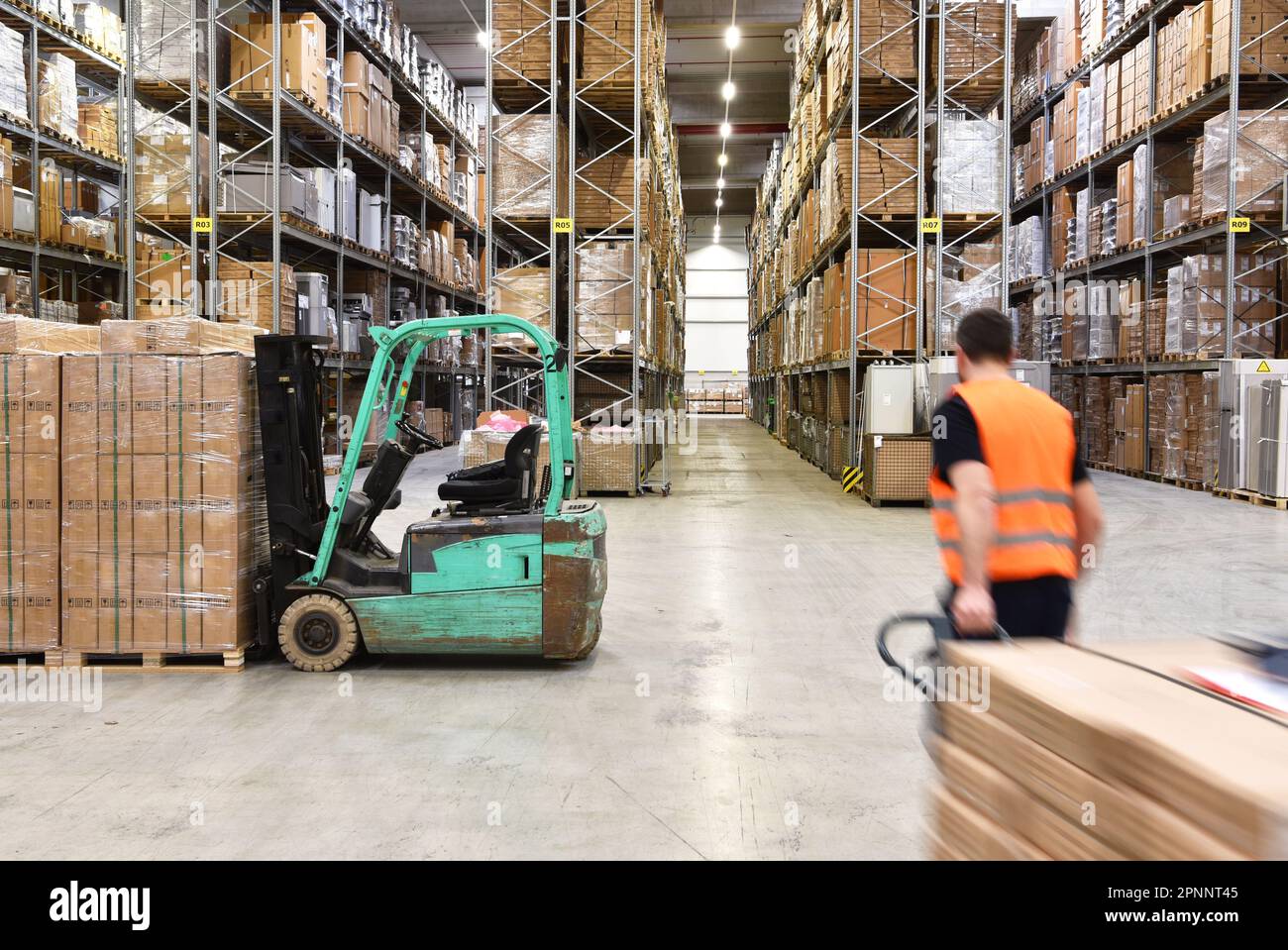 warehouse worker in a forwarding agency - interior with forklift ...