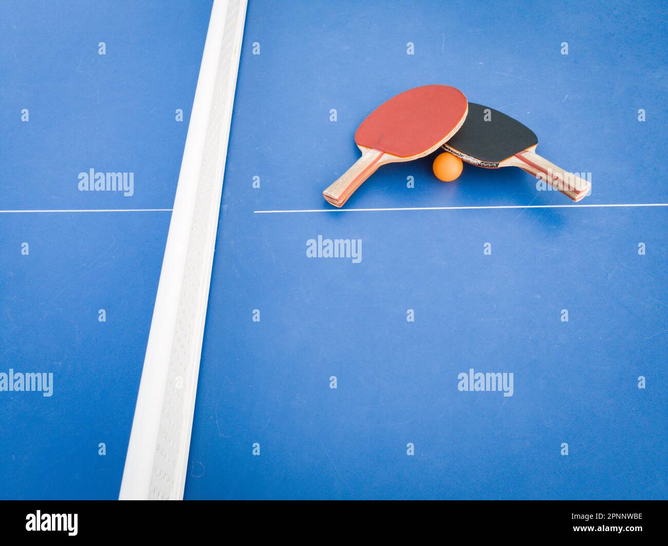 The professional ping pong rackets on a vibrant blue ping pong table ...