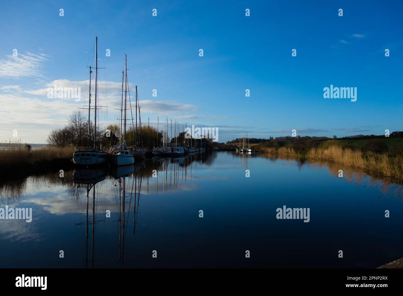 the Exeter Ship Canal at Topsham with a few clouds and boats reflected ...