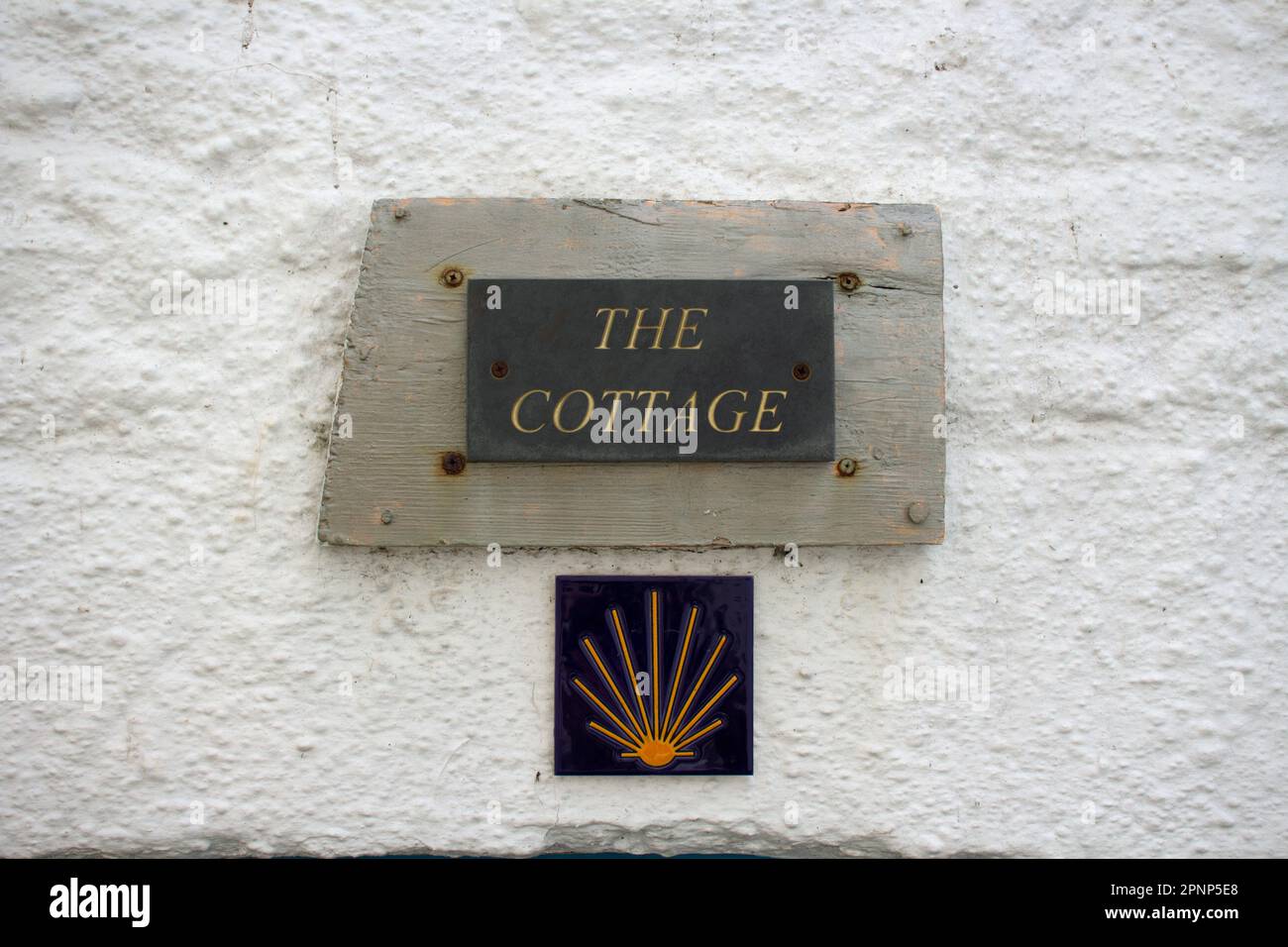 The Cottage sign with gold letters carved in grey slate fixed to a ...