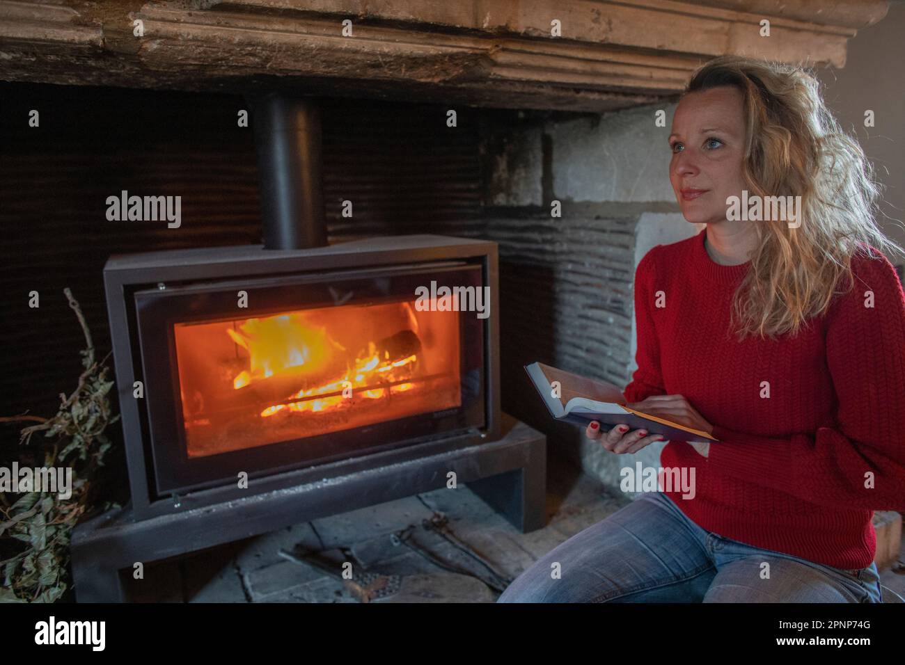 Woman sitting near a stove and reading the bible Stock Photo - Alamy