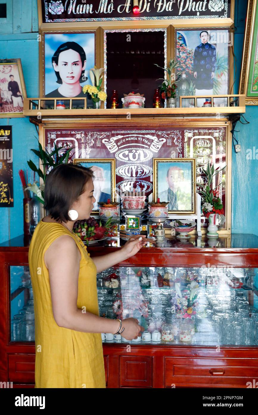 Ancestor altar. The veneration of the dead at home. Woman praying ...