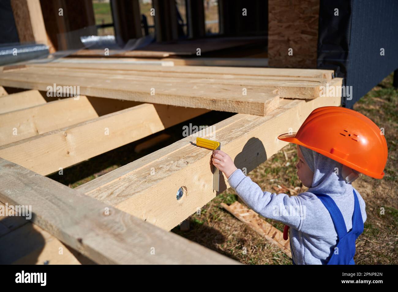 Boy toddler playing as builder on construction site. Child carpenter in ...