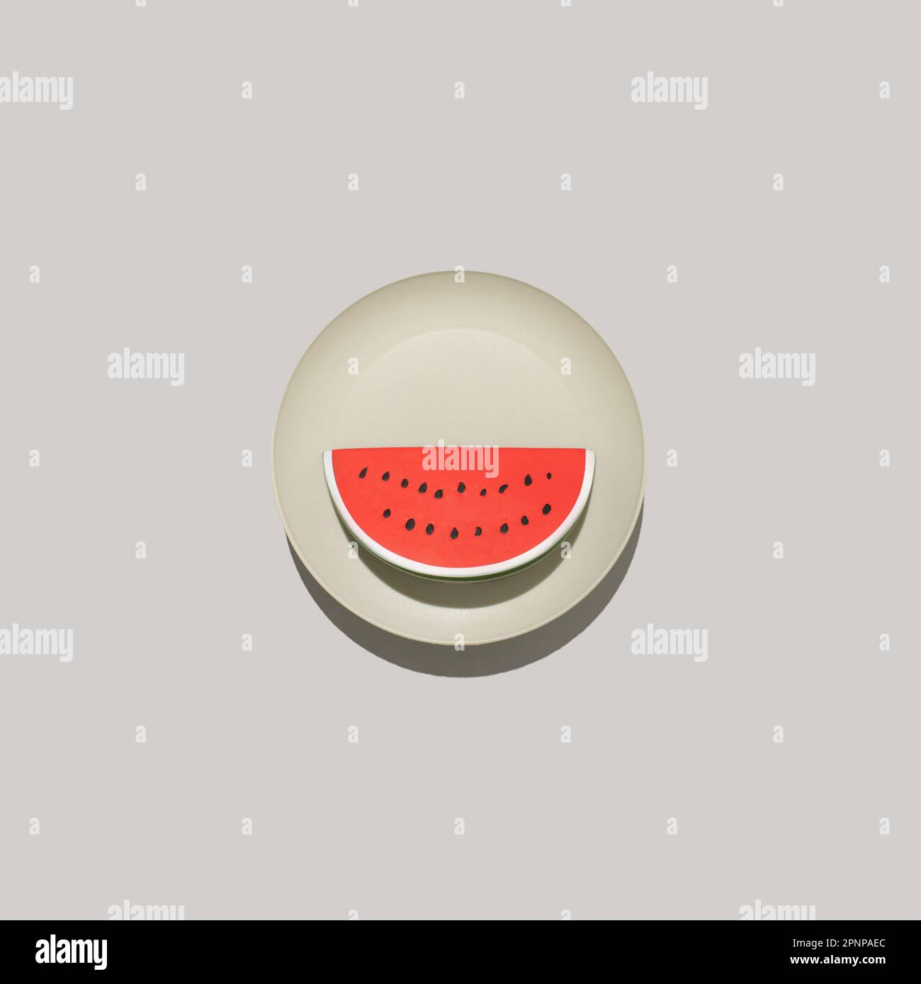 Slice of rubber watermelon on plate. Minimal summer fruit concept Stock ...