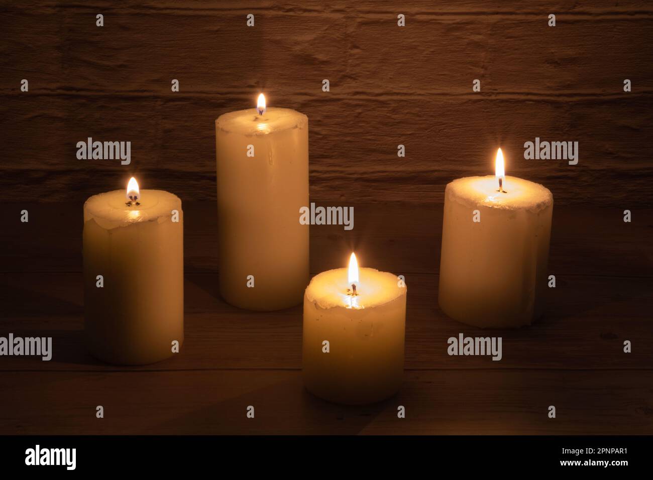 photo of several lighted candles standing on a table side by side Stock ...