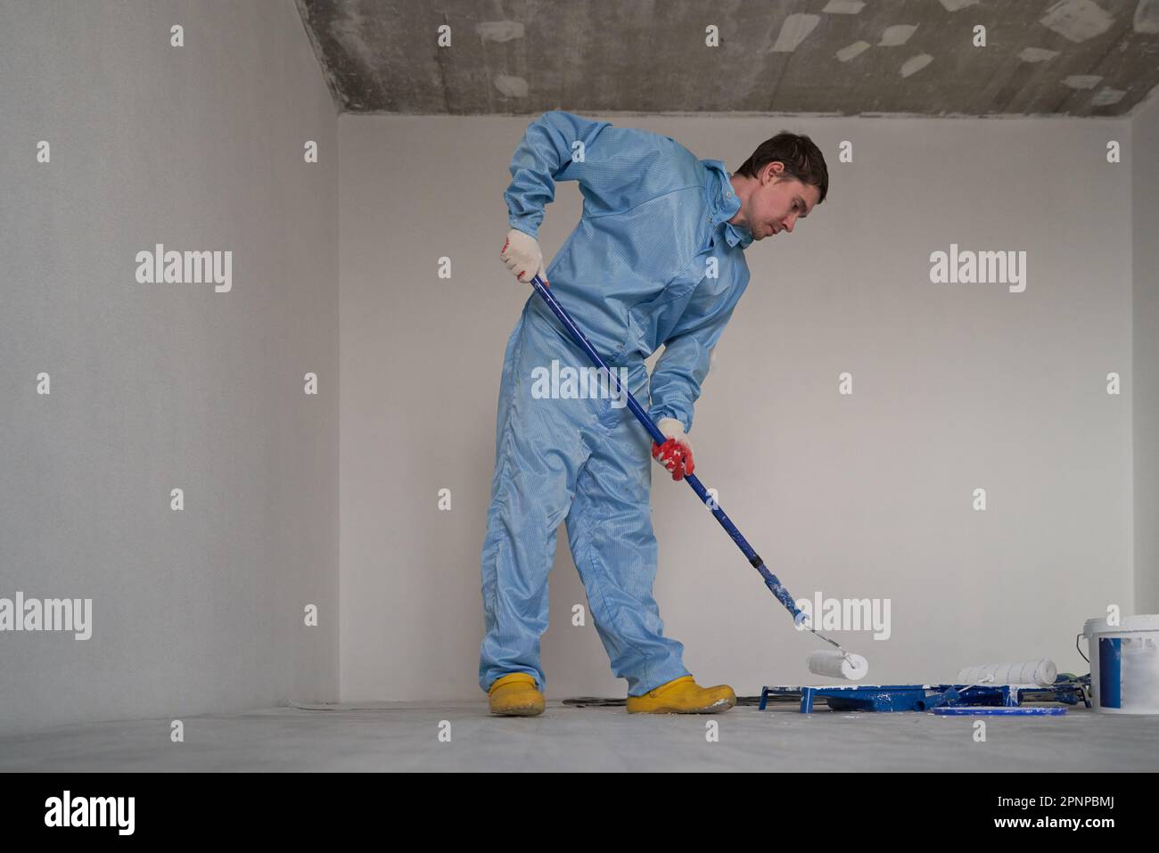 Man paints the ceiling with a roller. Concept of home makeover and ...