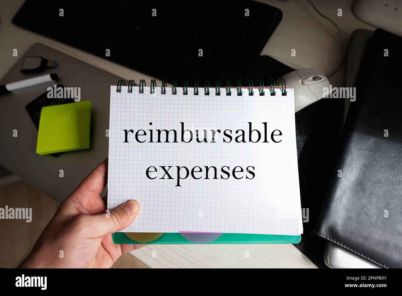 Reimbursable expenses word on notebook holding man against desktop ...