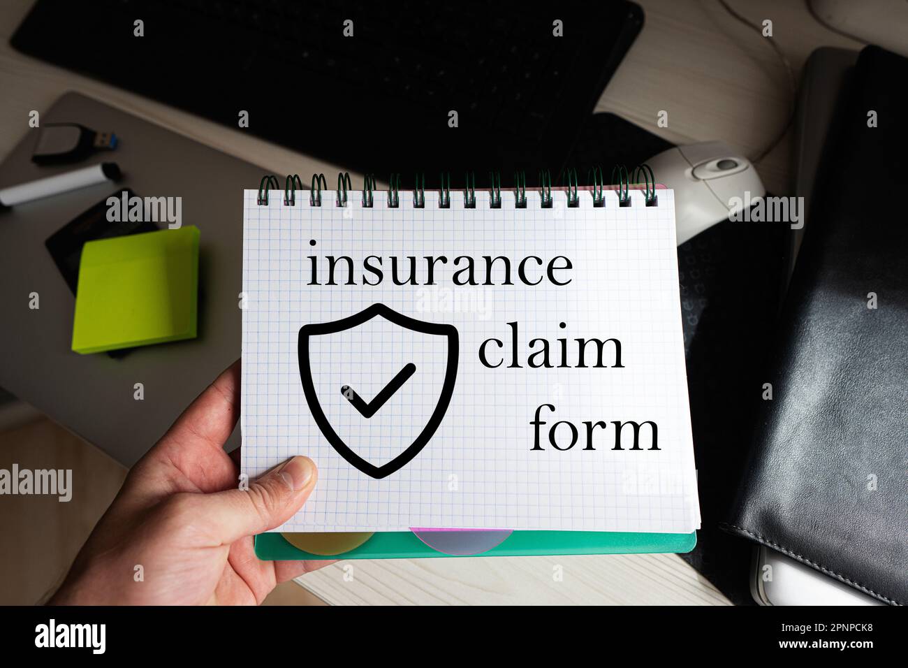 Insurance claim form word on notebook holding man against desktop Stock ...