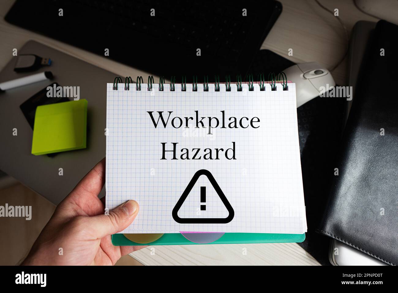 Workplace hazard word on notebook holding man against desktop Stock ...