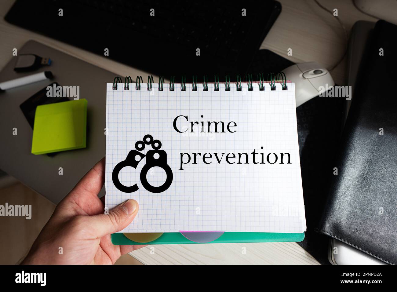 Crime prevention word on notebook holding man against desktop Stock ...