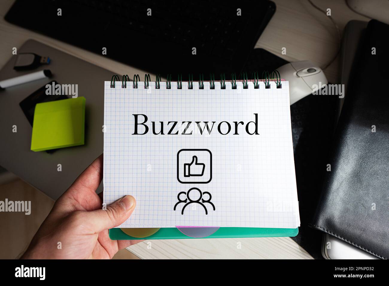 Buzzword word on notebook holding man against desktop Stock Photo - Alamy