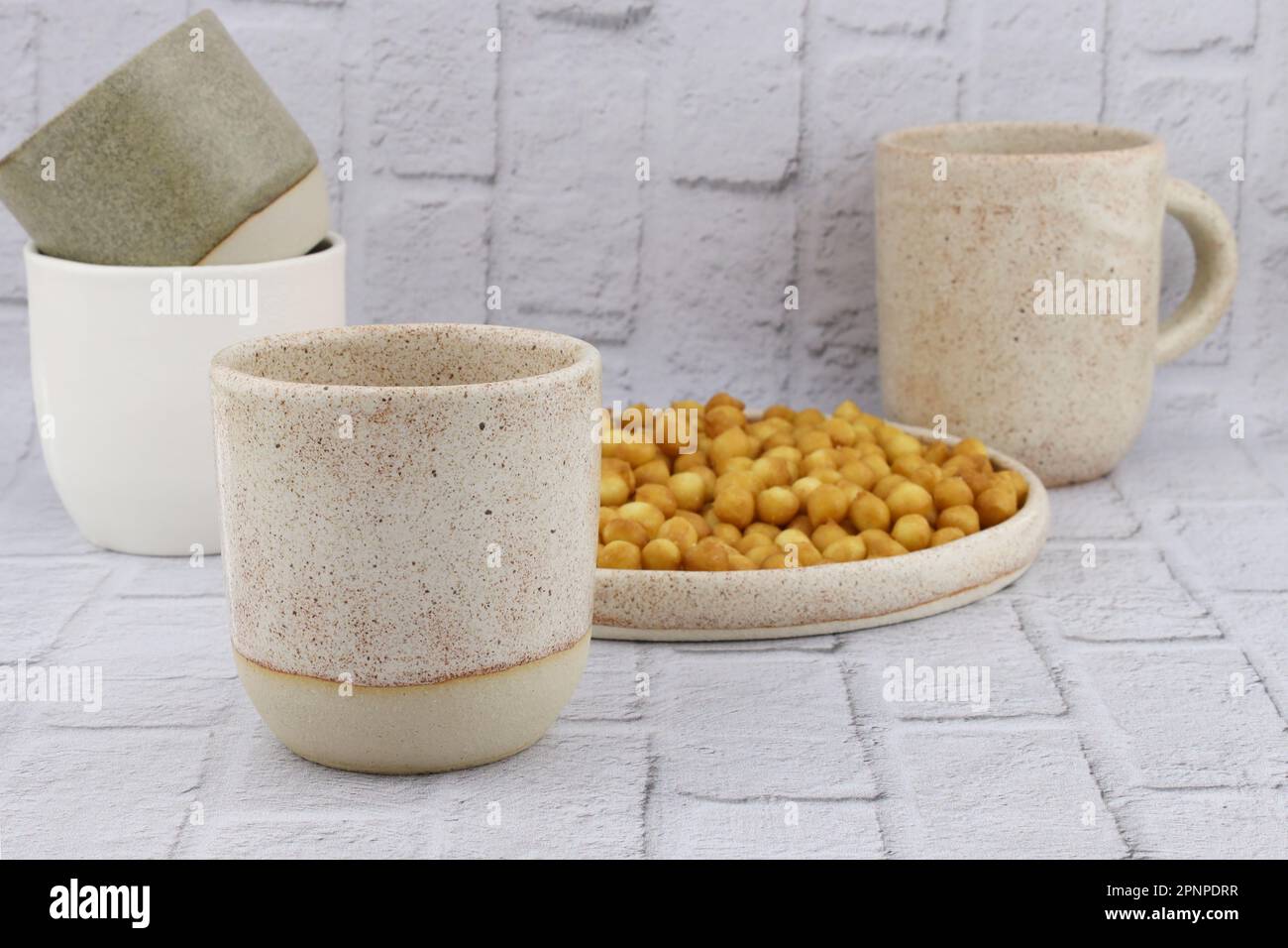 Ceramic cups in different sizes and colors. set of glasses and plates ...