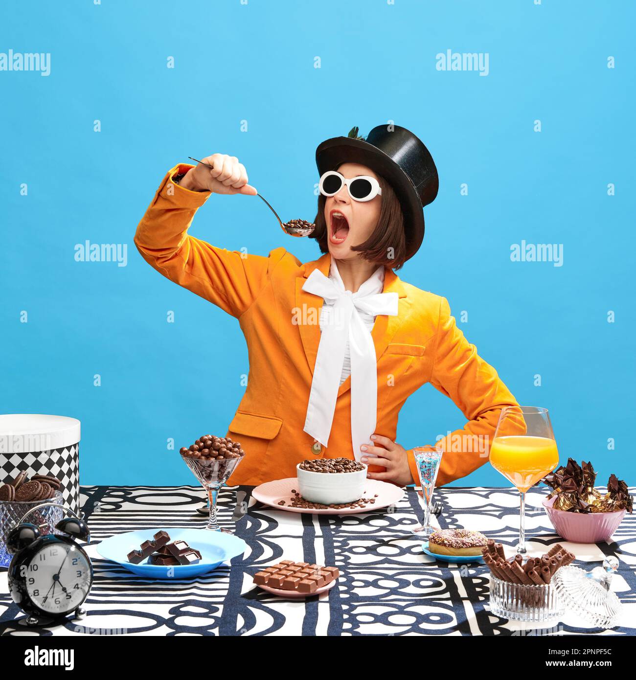 Eccentric, stylish, funny woman in cylinder and sunglasses passionately ...