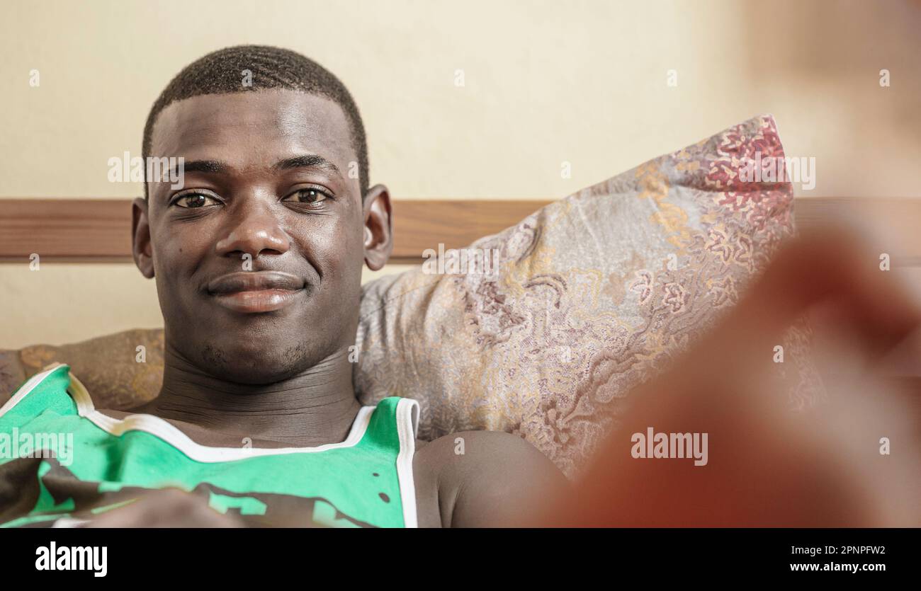 This relaxed and handsome African American young man is laying on his ...