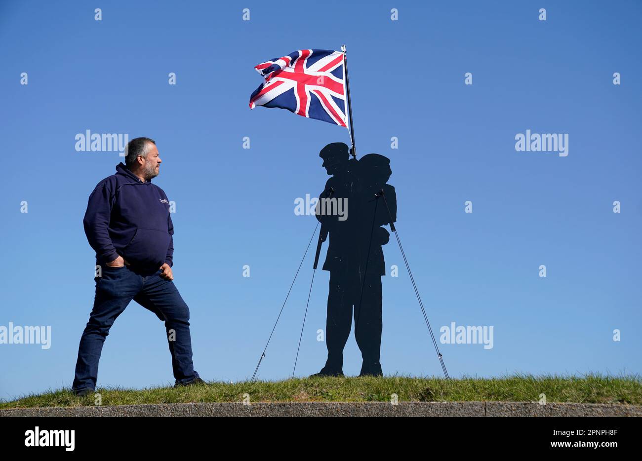 Dan Barton, creator of Standing with Giants, stands next to a ...