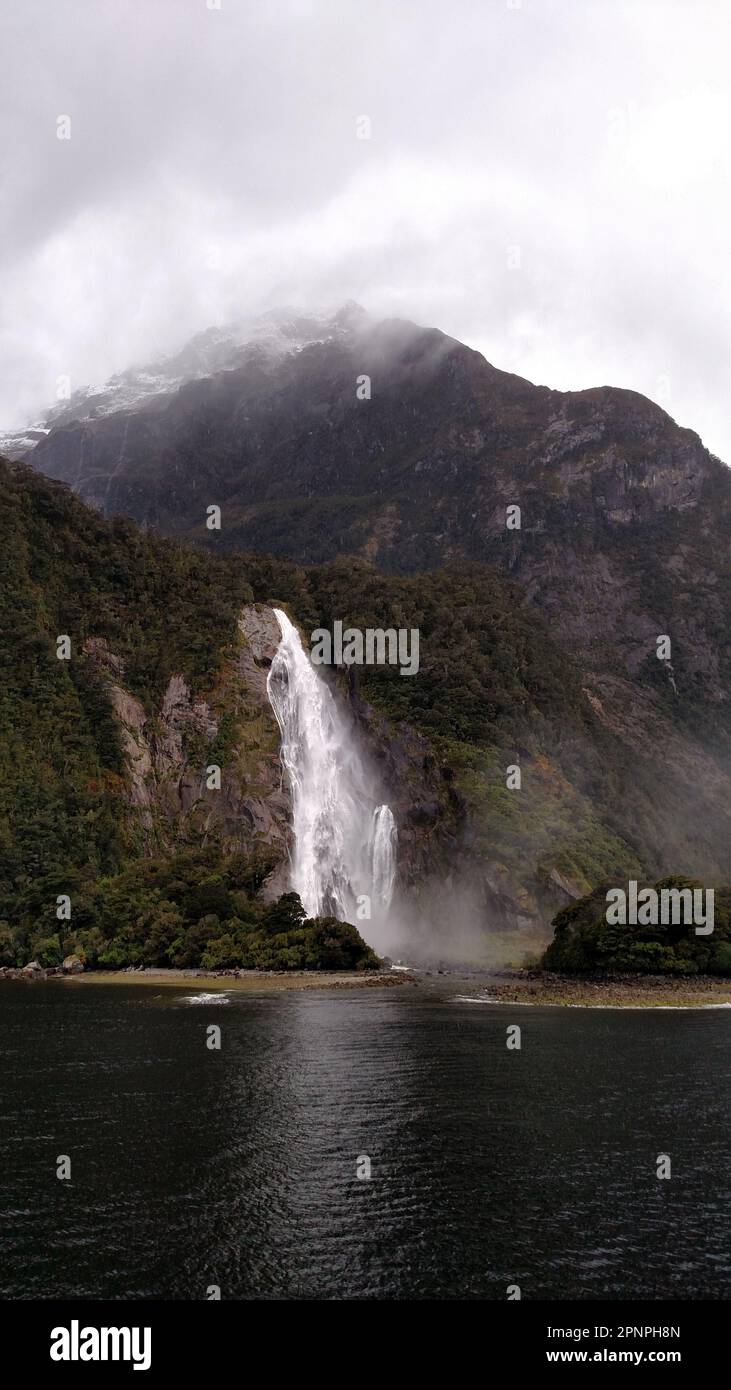 A tranquil scene of a cascading waterfall in a lush, green valley ...