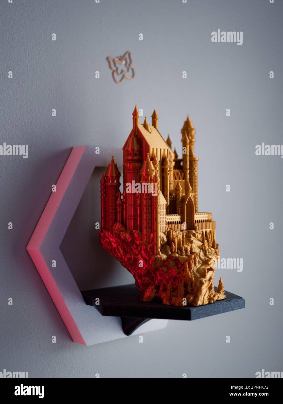 a bright golden castle mounted on a shelf on the wall with a dark ...